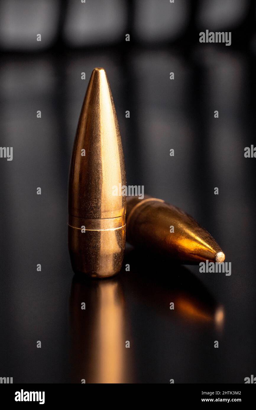 Bullet isolated on black background with reflexion. Rifle bullets close ...