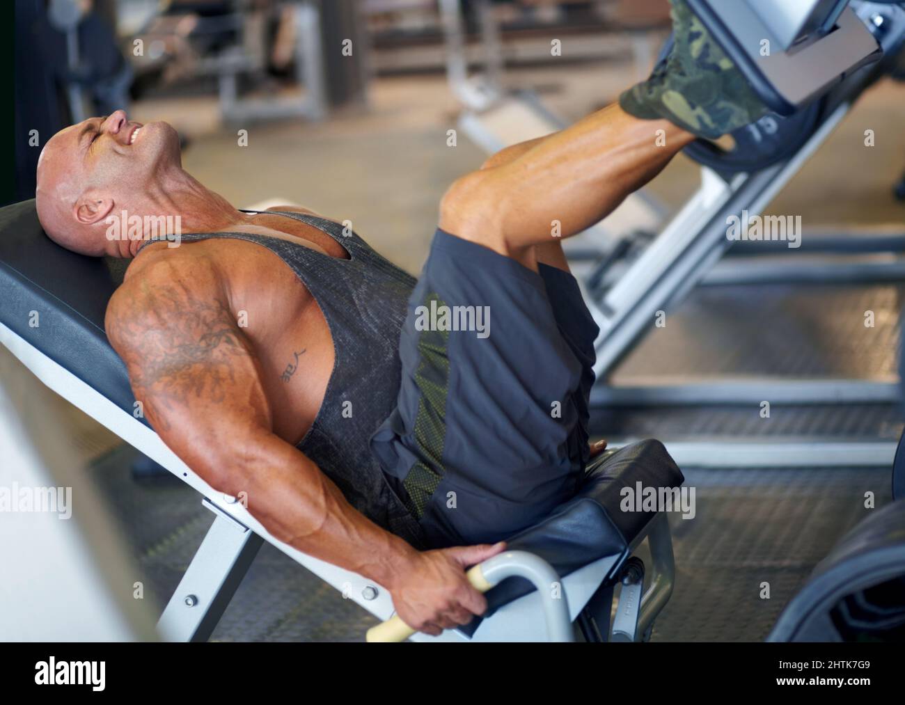Feeling determined. Shot of a male bodybuilder doing leg exercises on a ...