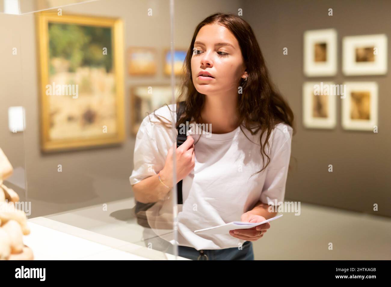 Girl visitor looks at the exhibit in the museum, located behind the ...