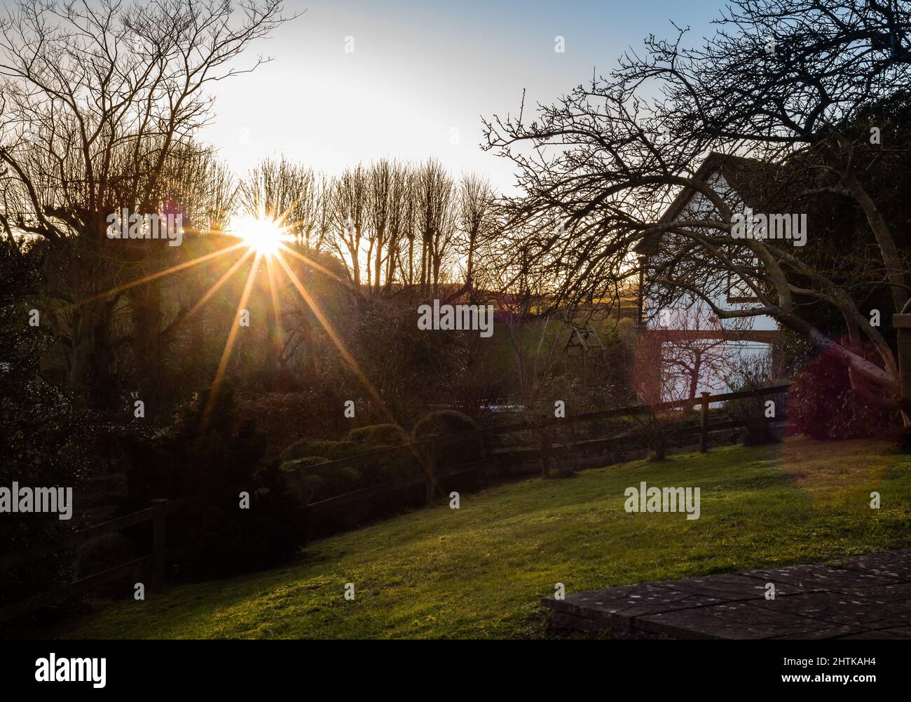 The January Sun sets on a Winter Country Garden Stock Photo - Alamy
