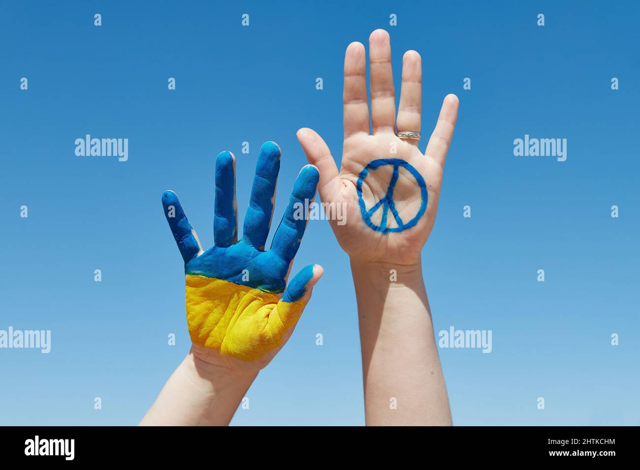 Females hand painted in ukrainian flag colors and peace sign against ...