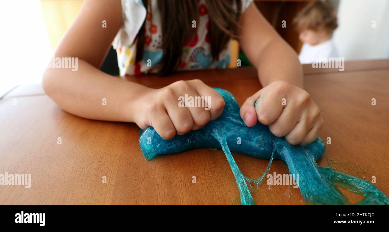 Child hands playing with slime goo. Little girl close-up hand and ...