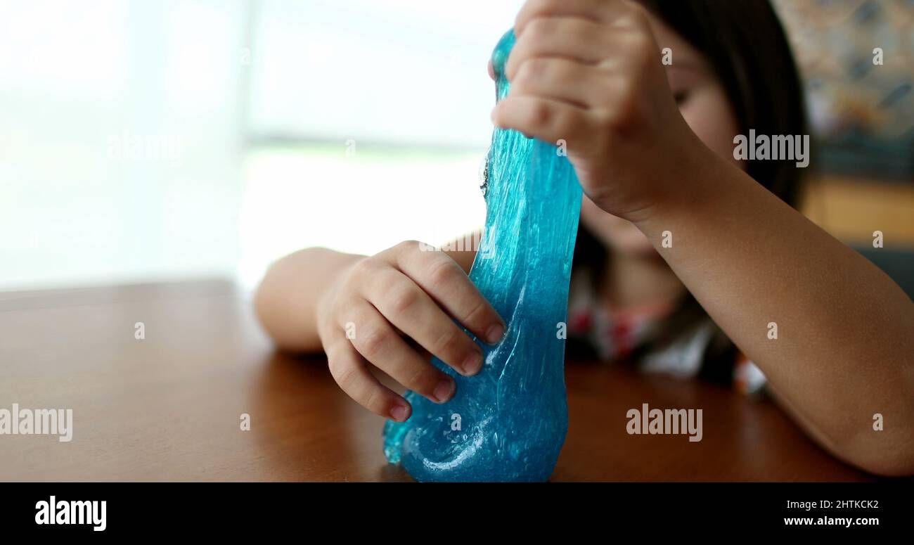 Child hands playing with slime goo. Little girl close-up hand and ...