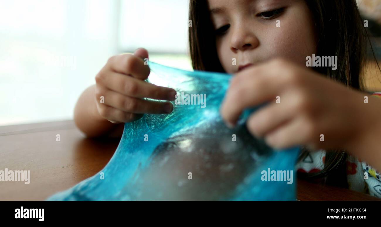 Child hands playing with slime goo. Little girl close-up hand and ...