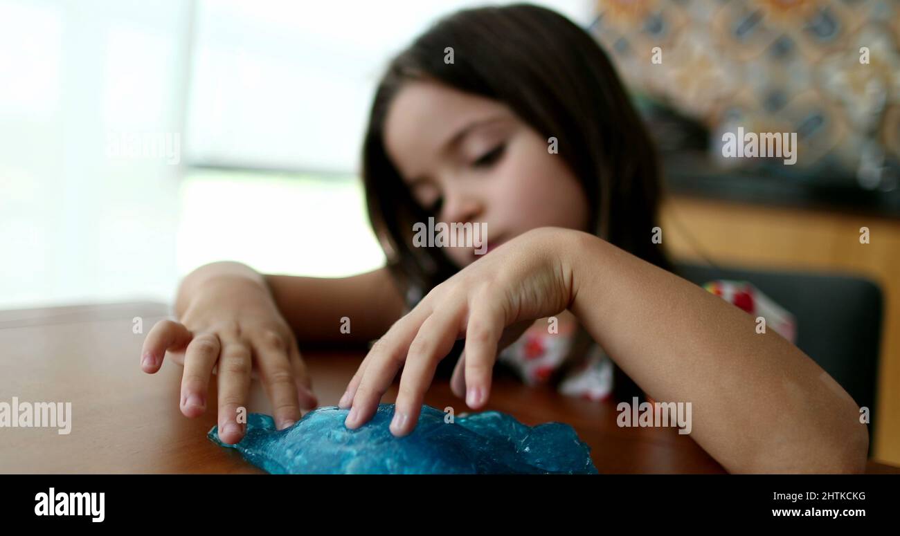 Child hands playing with slime goo. Little girl close-up hand and ...