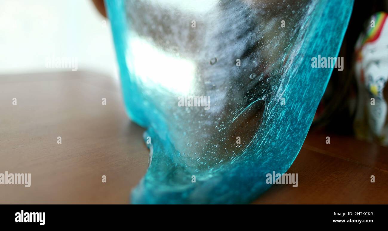 Child hands playing with slime goo. Little girl close-up hand and ...