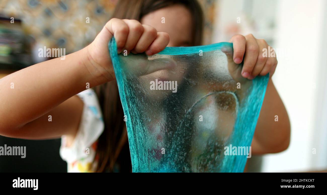 Child hands playing with slime goo. Little girl close-up hand and ...