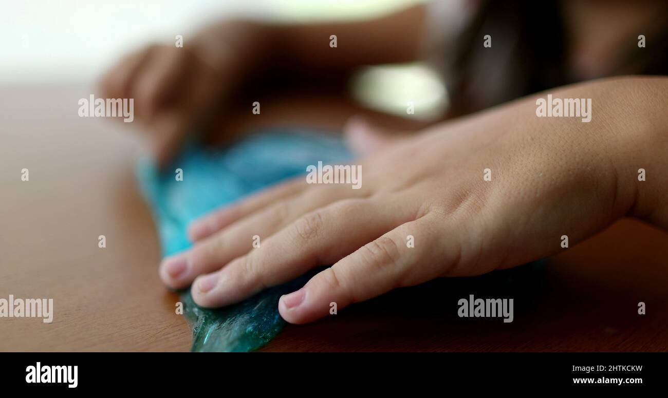 Child hands playing with slime goo. Little girl close-up hand and ...