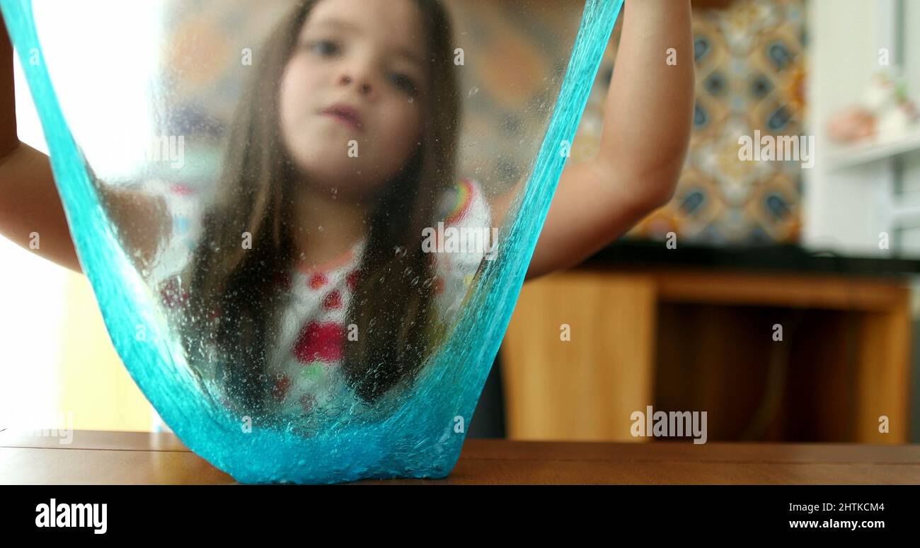 Child hands playing with slime goo. Little girl close-up hand and ...
