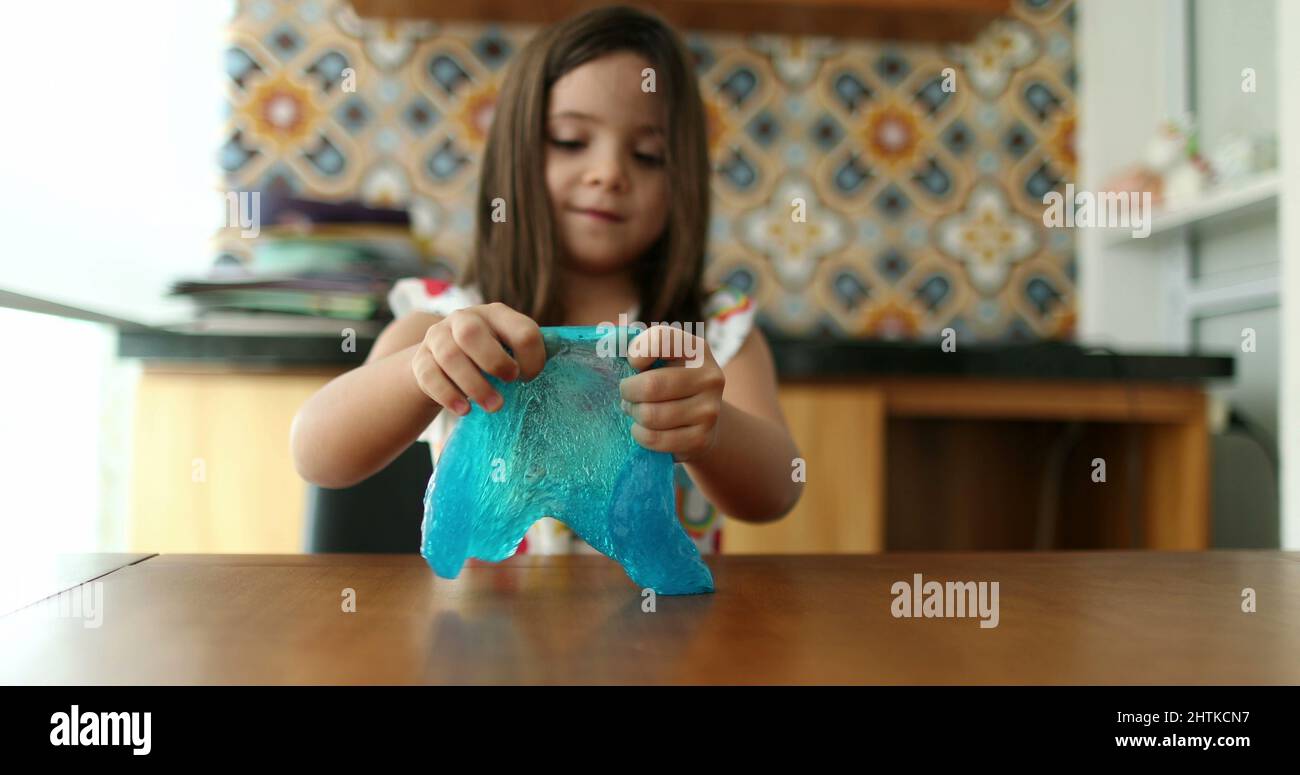 Child hands playing with slime goo. Little girl close-up hand and ...