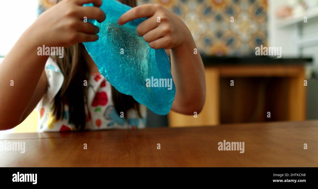 Child hands playing with slime goo. Little girl close-up hand and ...
