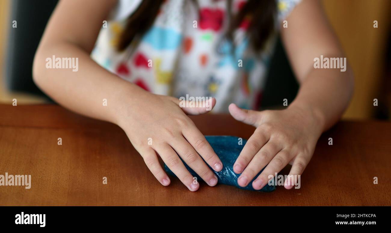Child hands playing with slime goo. Little girl close-up hand and ...