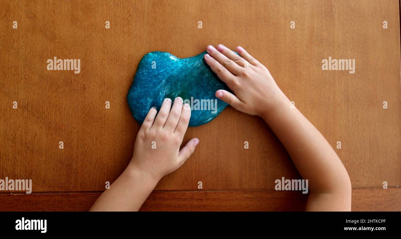 Child hands playing with slime goo. Little girl close-up hand and ...
