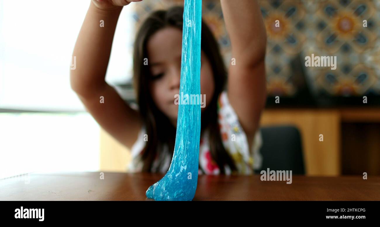 Child hands playing with slime goo. Little girl close-up hand and ...