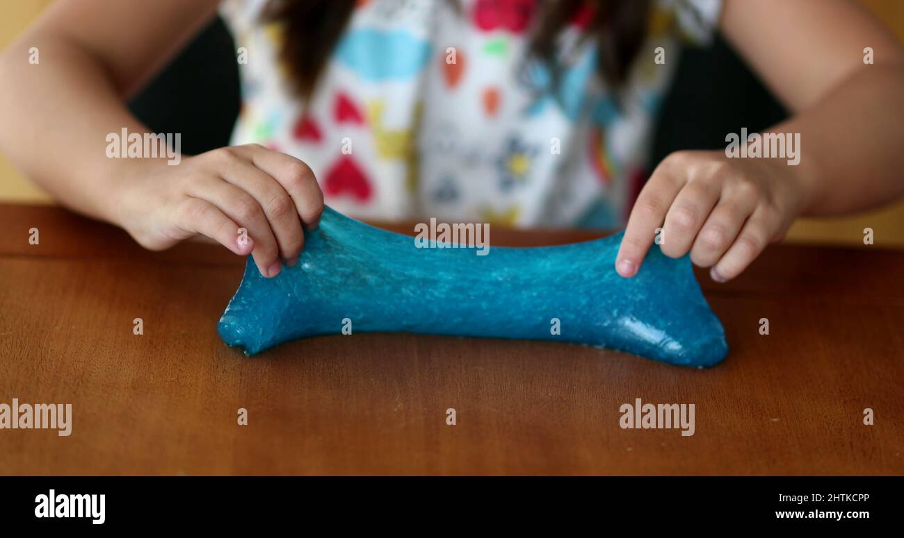 Child hands playing with slime goo. Little girl close-up hand and ...