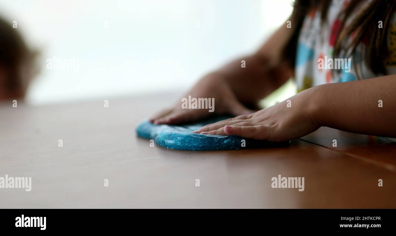 Child hands playing with slime goo. Little girl close-up hand and ...
