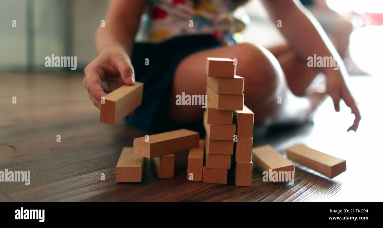 Child playing with wooden building blocks. Kid trial and error play ...