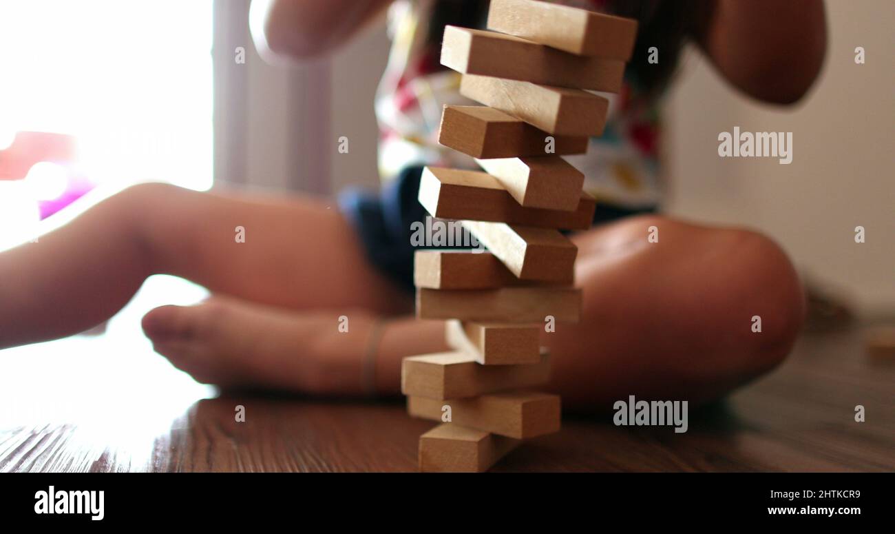 Child playing with wooden building blocks. Kid trial and error play ...