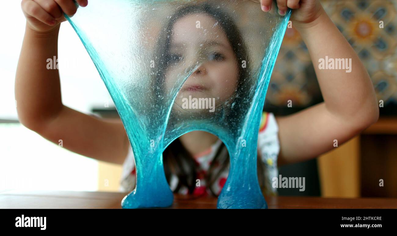 Child hands playing with slime goo. Little girl close-up hand and ...