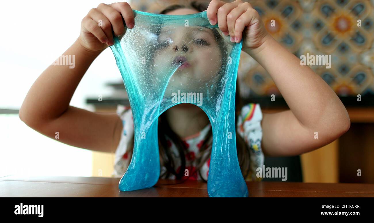 Child hands playing with slime goo. Little girl close-up hand and ...