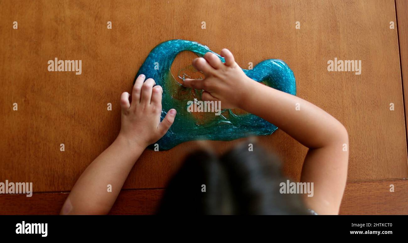 Child hands playing with slime goo. Little girl close-up hand and ...