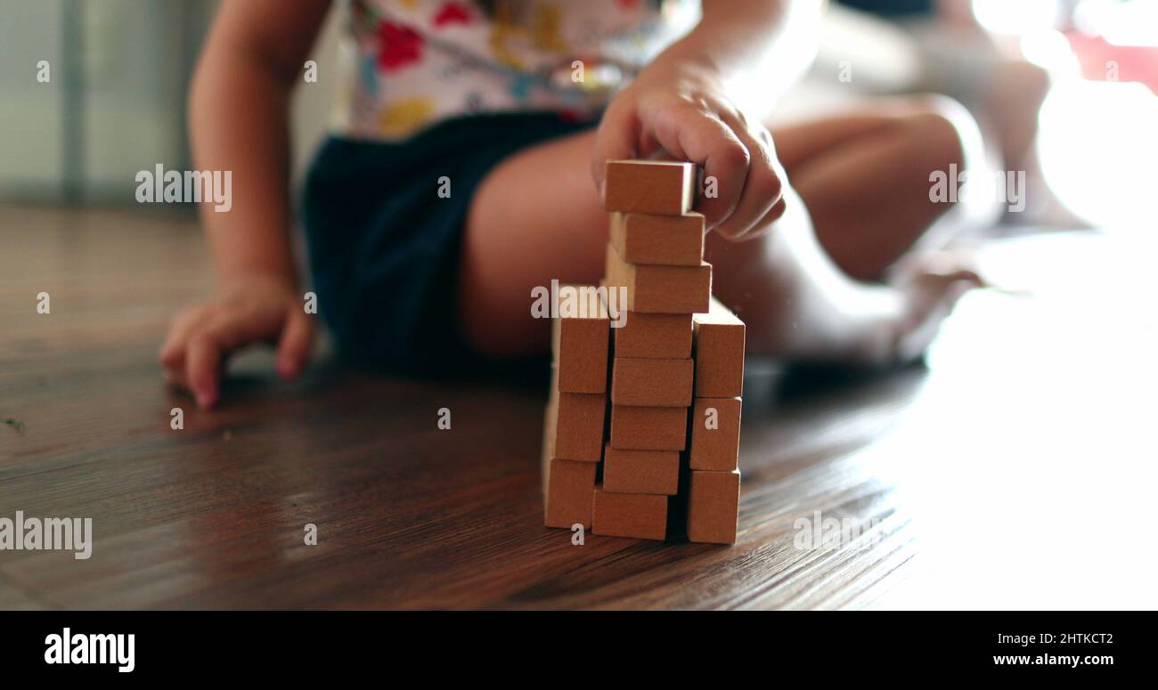 Child playing with wooden building blocks. Kid trial and error play ...