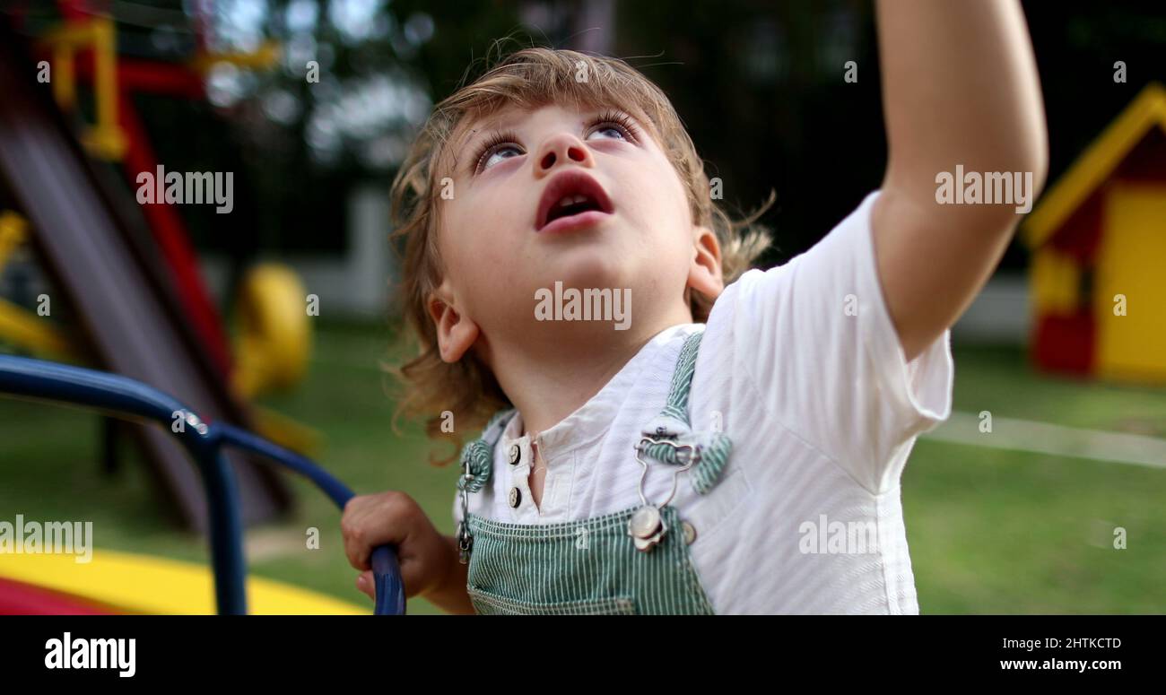 Child playing outside spinning on playground carousel Stock Photo - Alamy