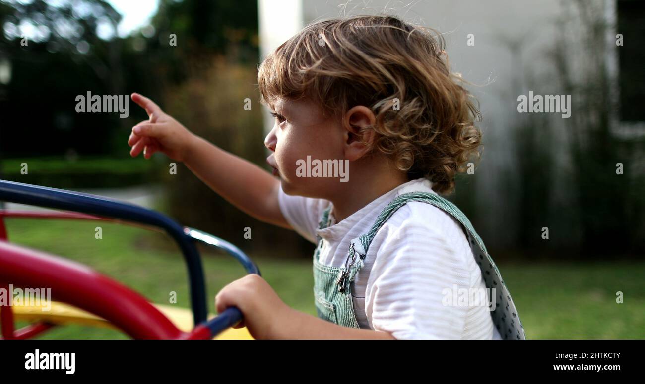 Cute baby toddler spinning on carousel at playground park Stock Photo ...
