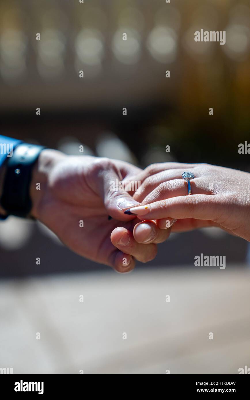 Vertical shot of couple holding hands wearing an engagement ring Stock ...