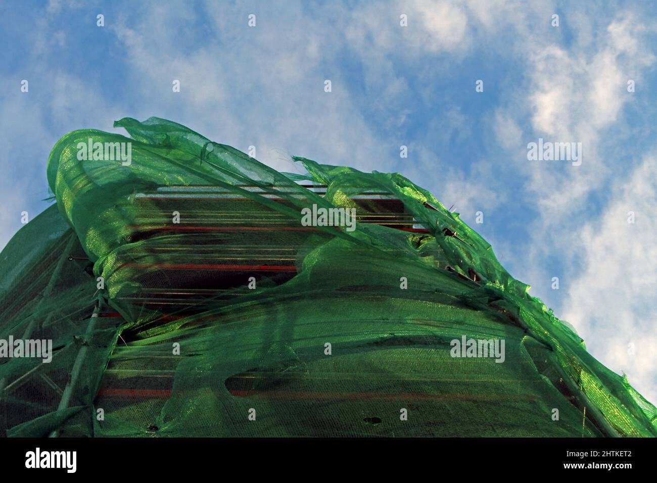 Green safety net used on a building, construction mesh netting during ...