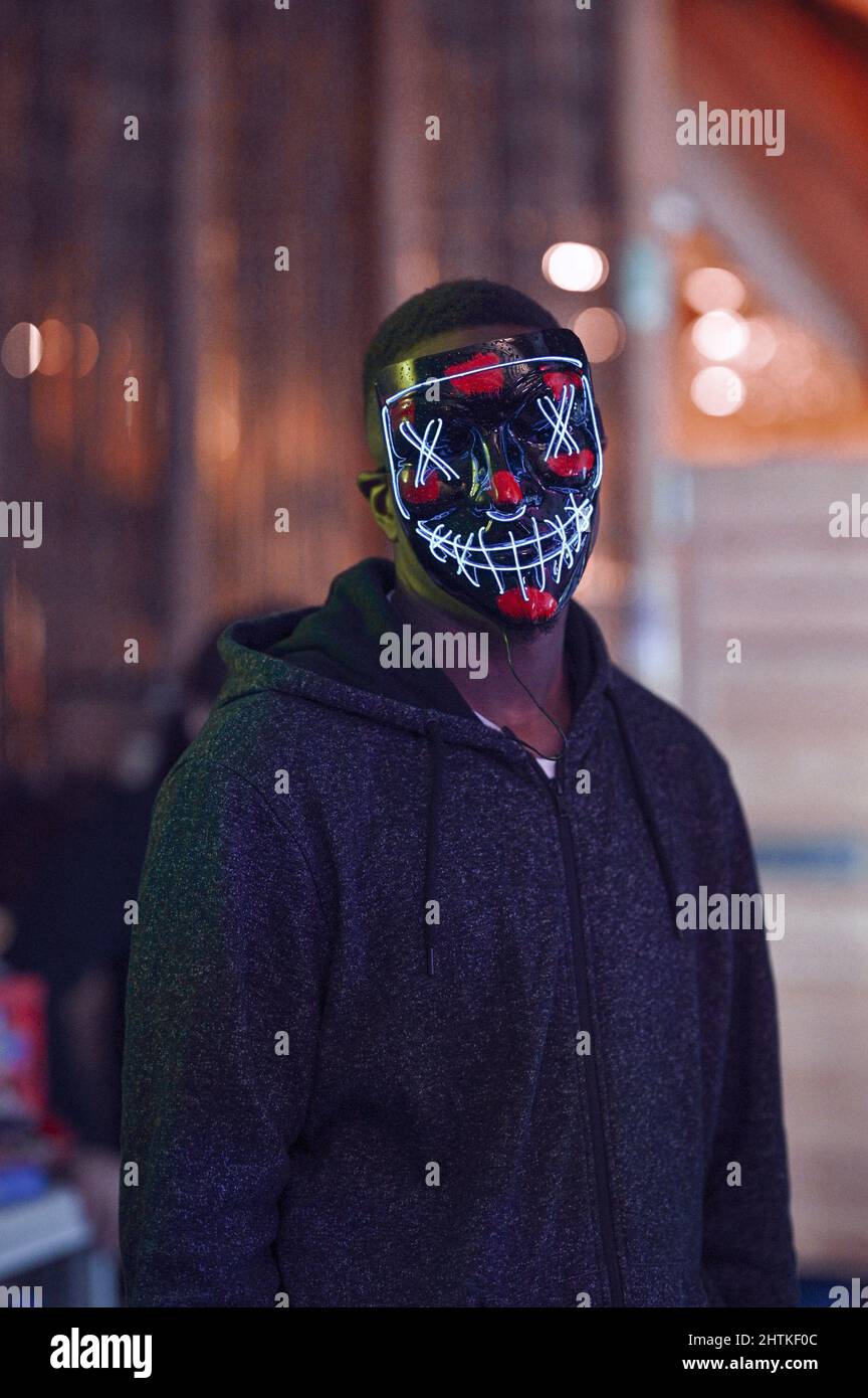 Closeup of a guy in a neon mask posing for a picture Stock Photo - Alamy