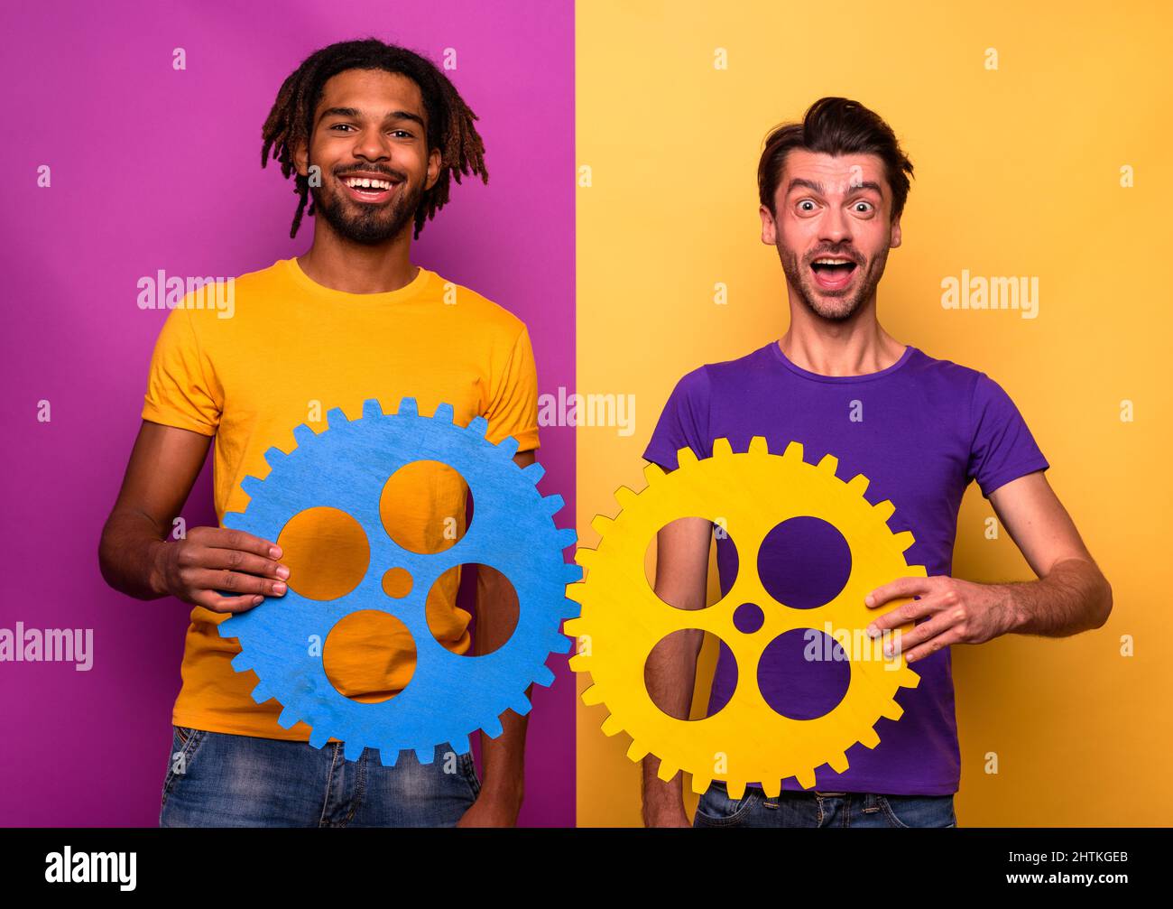 Two men join pieces of gears as concept of teamwork and partnership ...