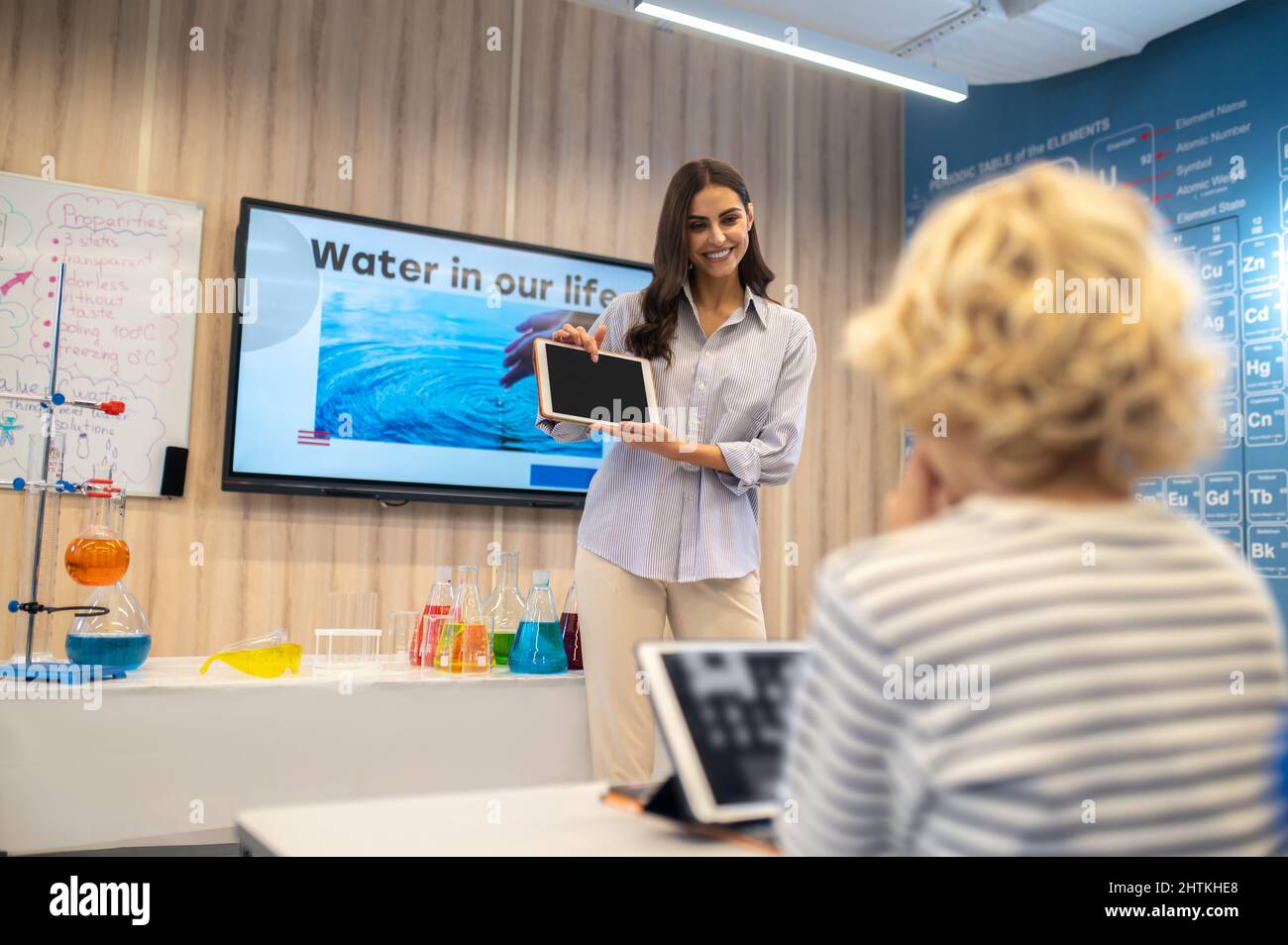 Woman pointing finger at tablet screen showing students Stock Photo - Alamy