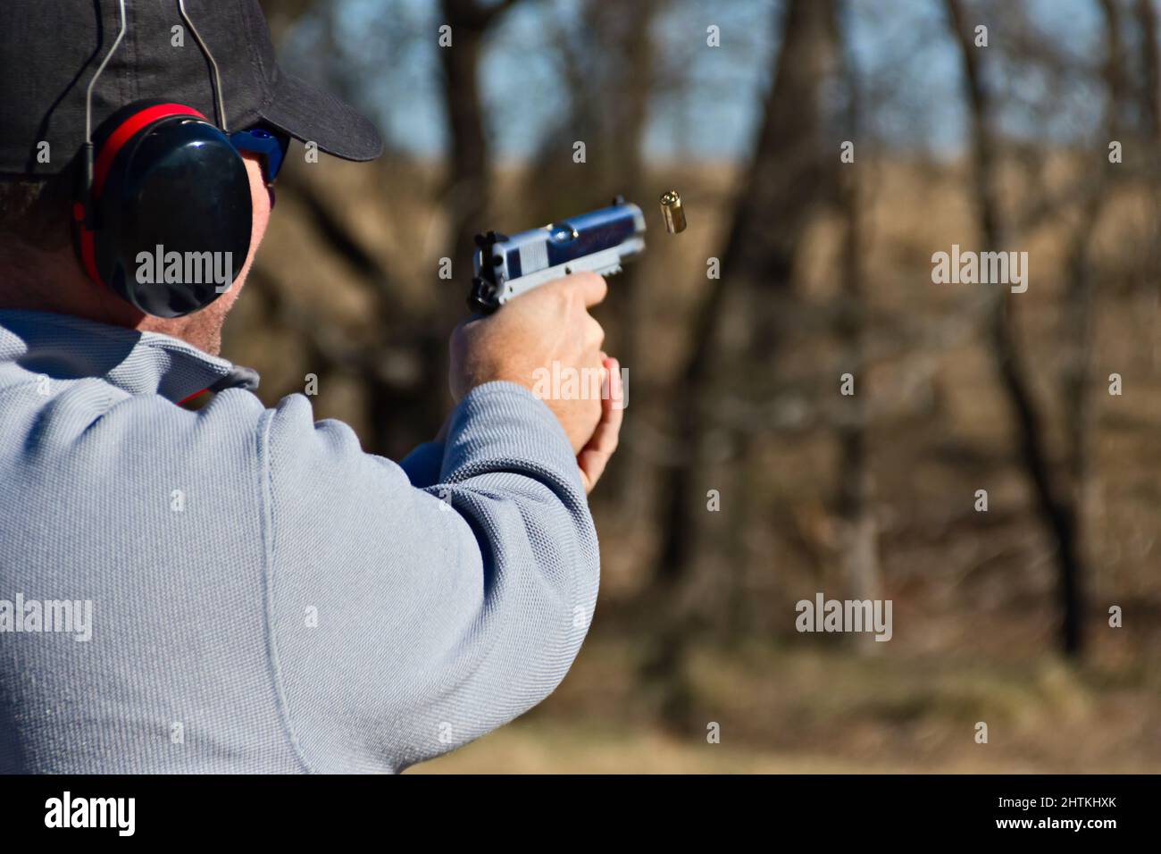 Man shooting outdoors with a pistol at a shooting range Stock Photo - Alamy