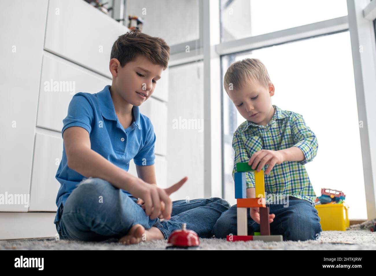 Focused involved child joining together building bricks Stock Photo - Alamy
