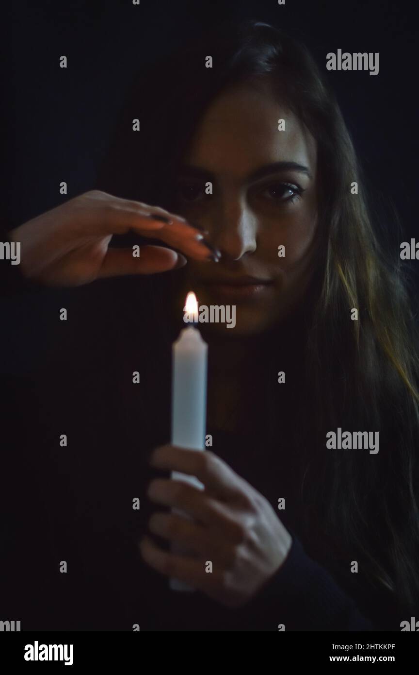 Playing with fire - young beautiful woman with long hair holding a ...