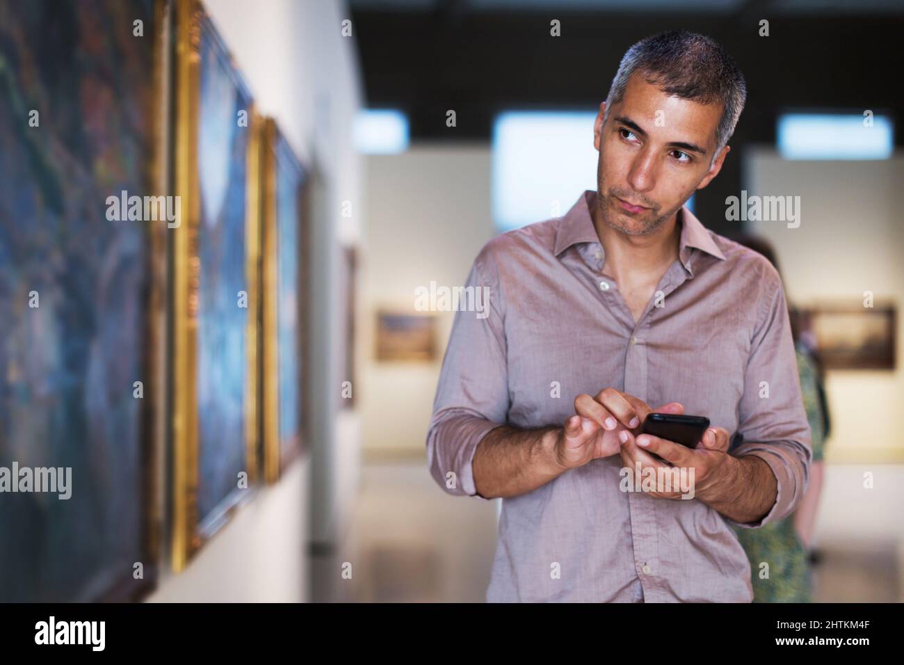Adult man is visiting museum and looking at the exposition with ...