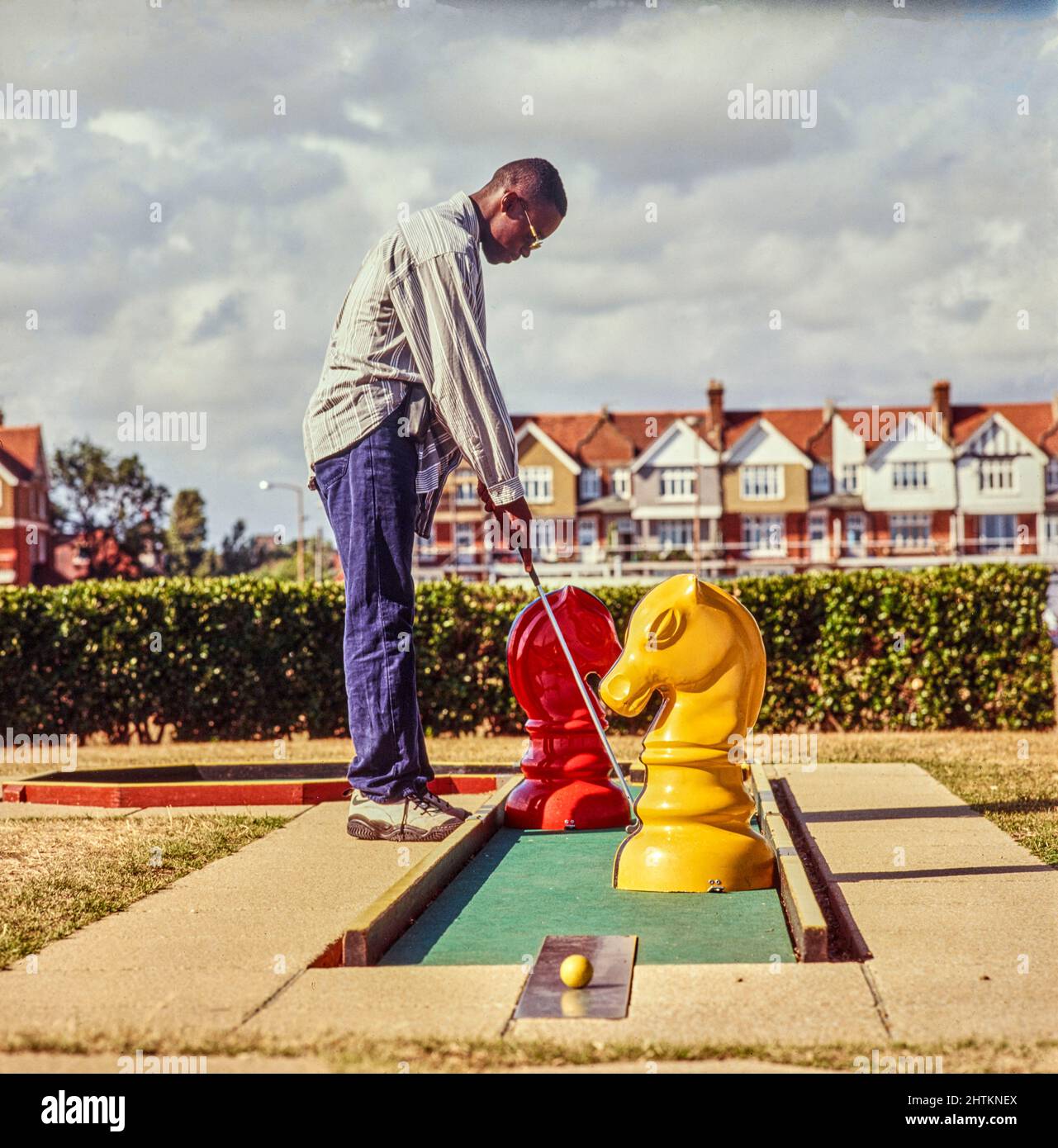 Afro-Caribbean male playing Miniature golf, minigolf, mini-putt, goofy ...