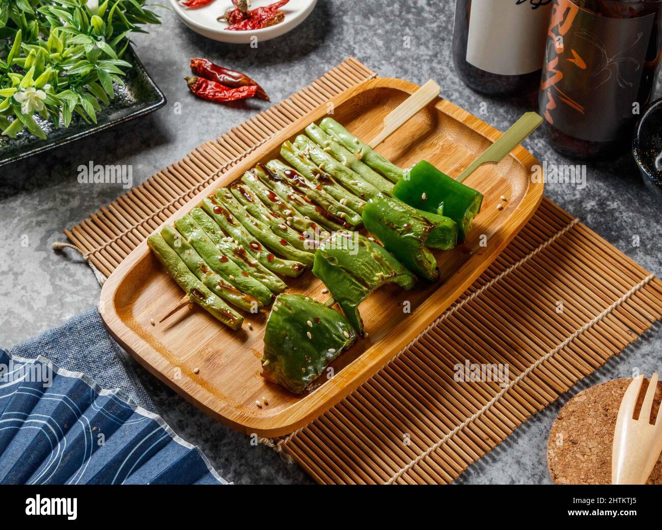 Four Seasons spicy grilled Green Pepper sticks in wooden dish isolated ...