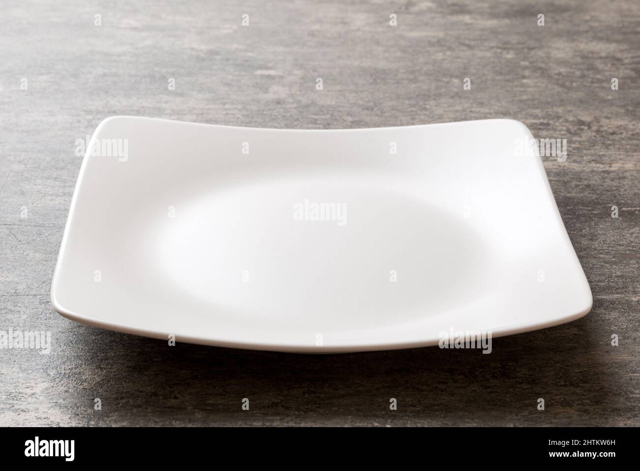 Perspective view of empty square plate on cement background. Empty ...