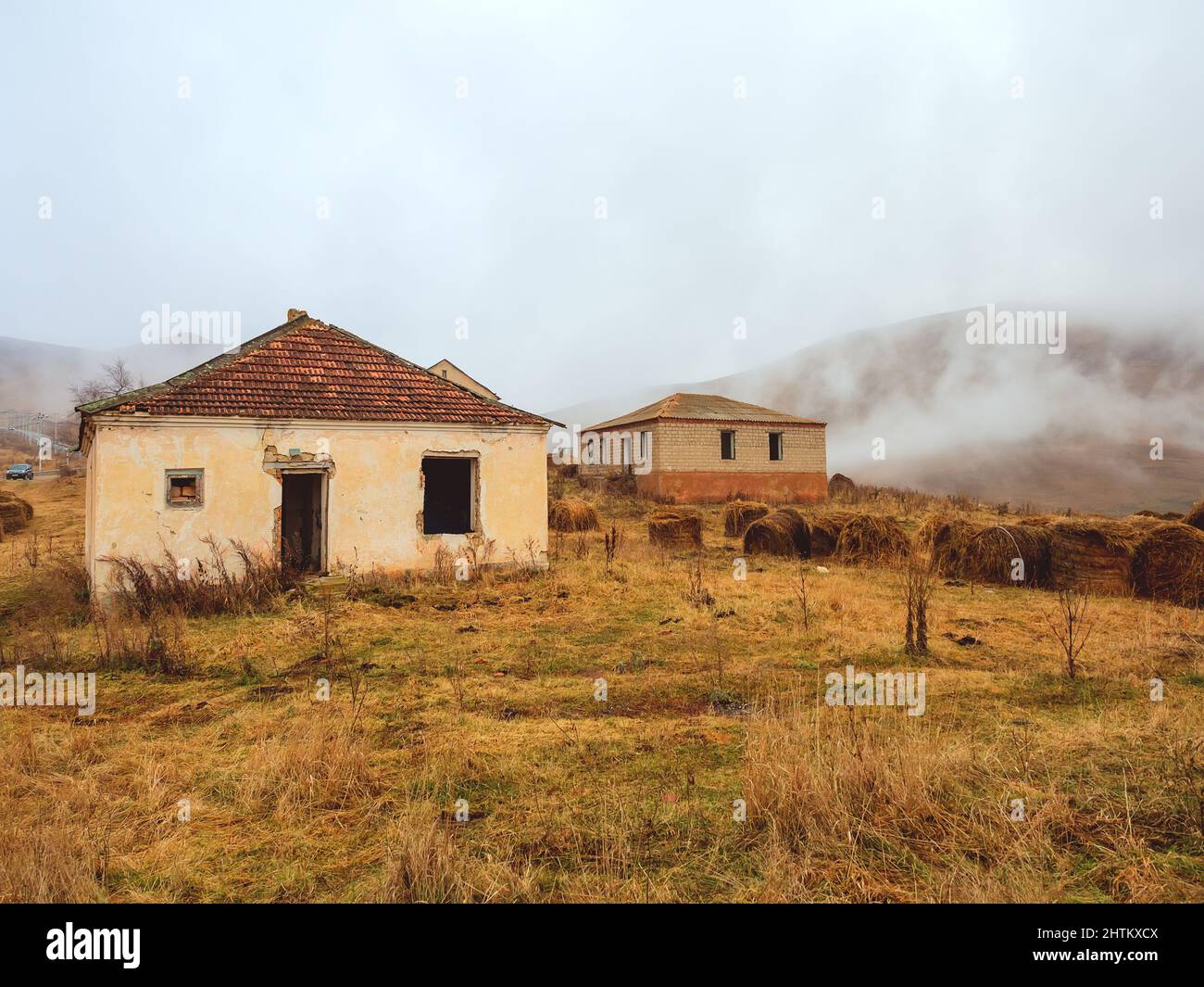 Countryside area with rolled haystacks and abandoned empty houses in ...