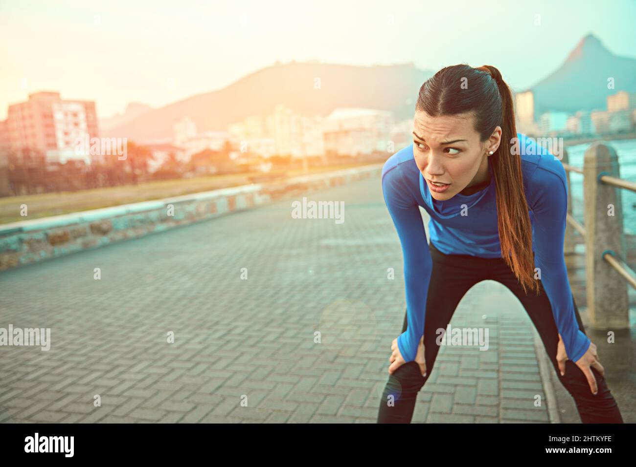 Take a break and try again. Shot of a sporty young woman taking a break ...