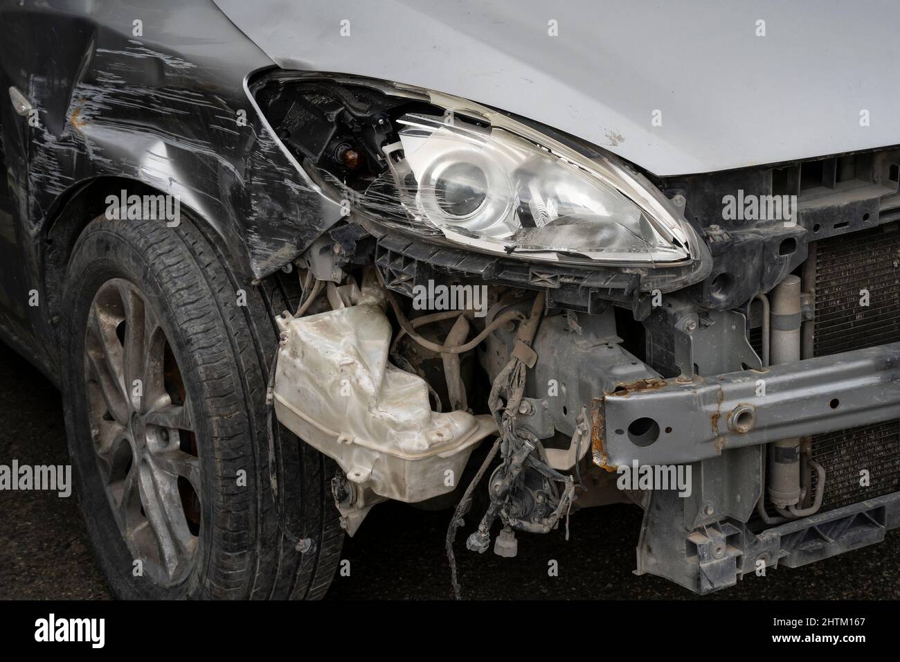 A close up image of a car after an accident, with a broken headlight ...