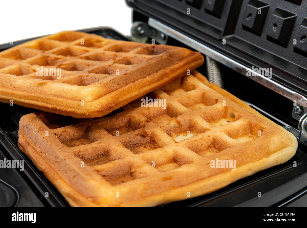 New modern waffle maker with waffles isolated on white. homemade baking ...