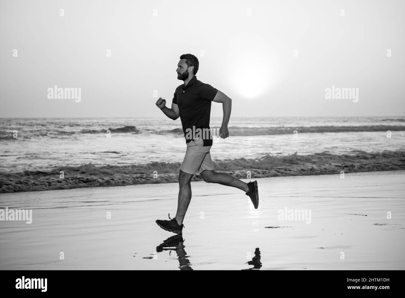 Sporty man runner running in summer. Man running on the beach at sunset ...