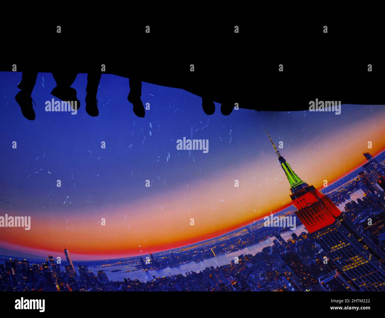 The legs of riders dangle off of a flying theater ride that pitches ...