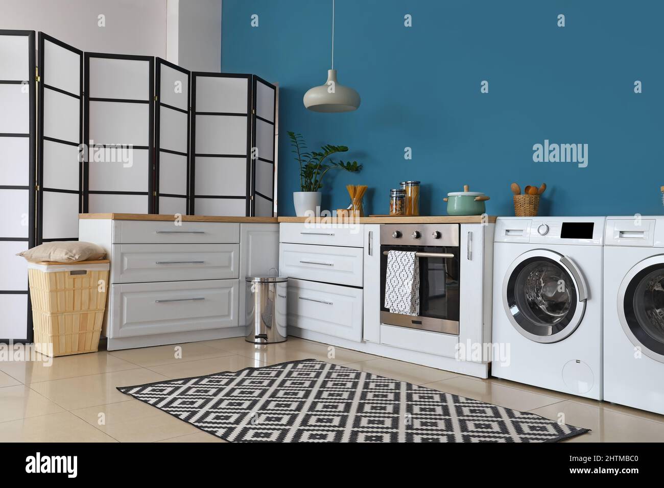 Interior of stylish kitchen with modern washing machines, oven and ...