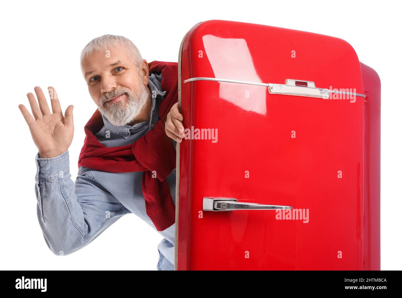 Mature man with red fridge waving hand on white background Stock Photo ...