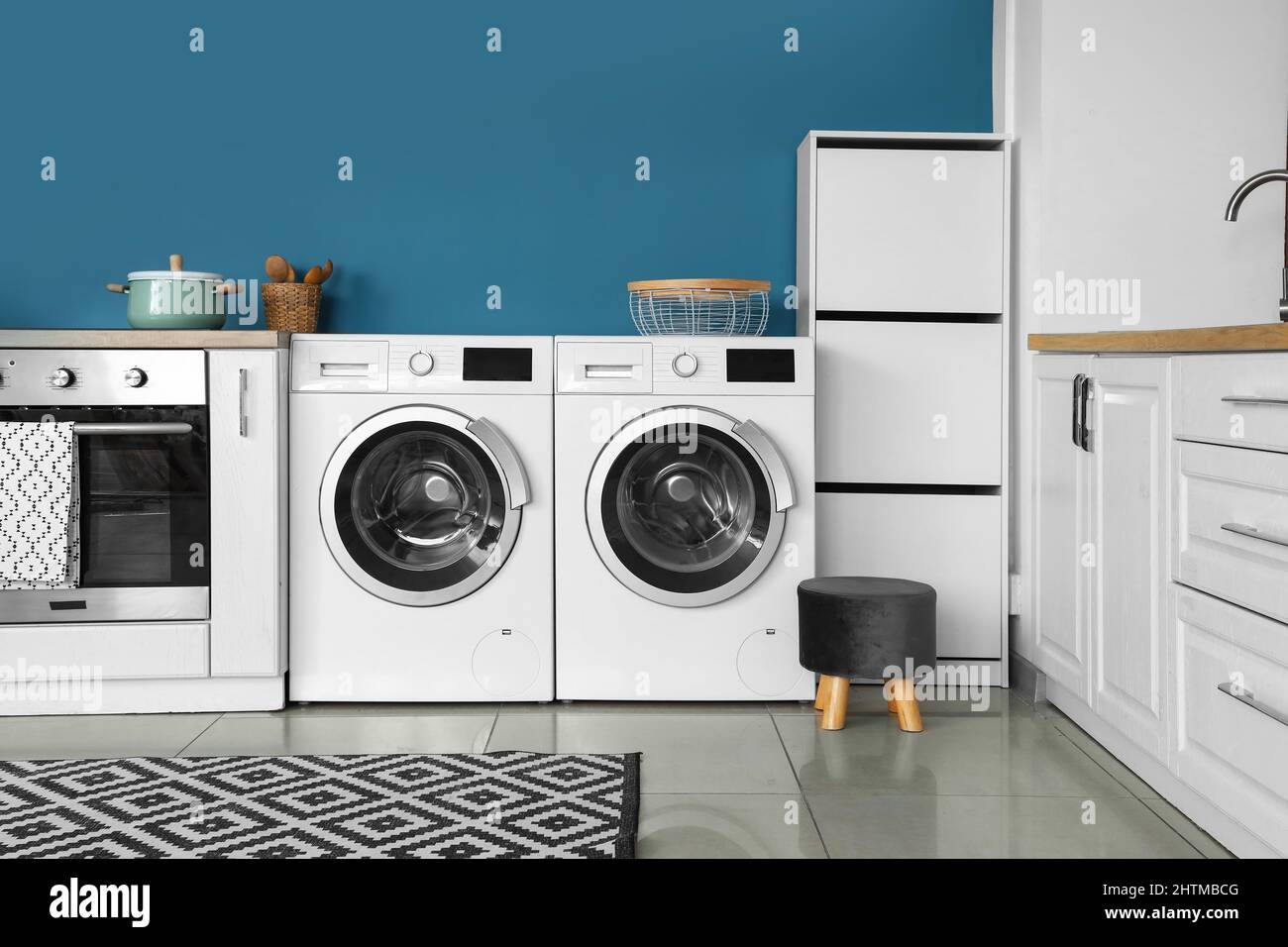 Interior of stylish kitchen with modern washing machines, oven and ...