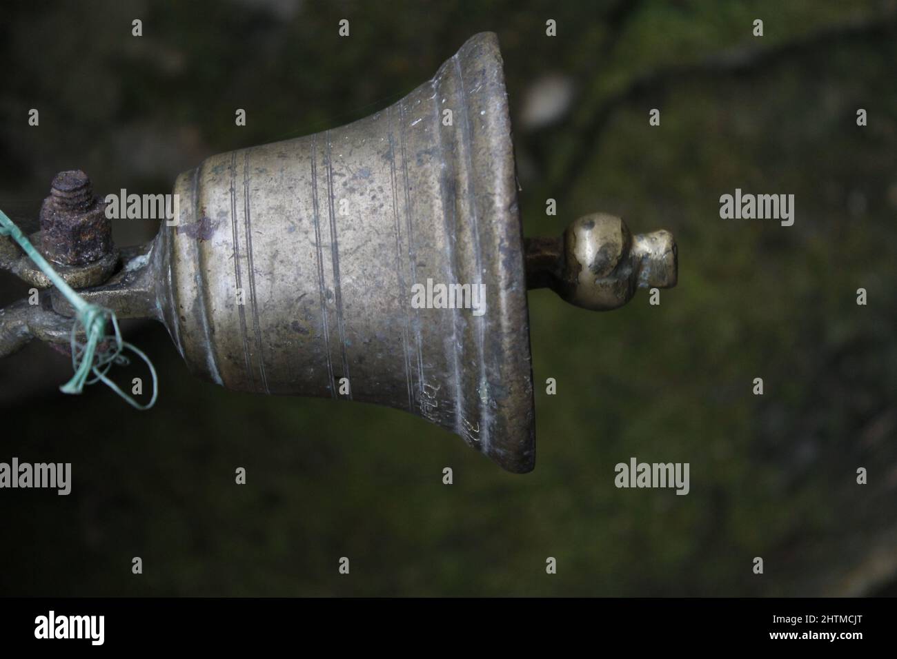 Old rusted metalic hanged bell on a blurry green background Stock Photo ...